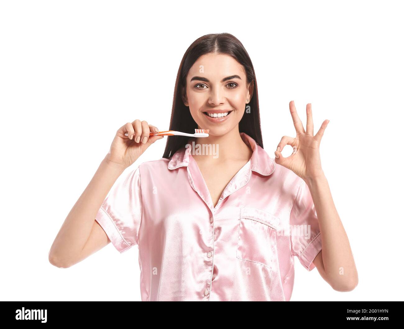 Beautiful woman brushing teeth and showing OK on white background Stock ...