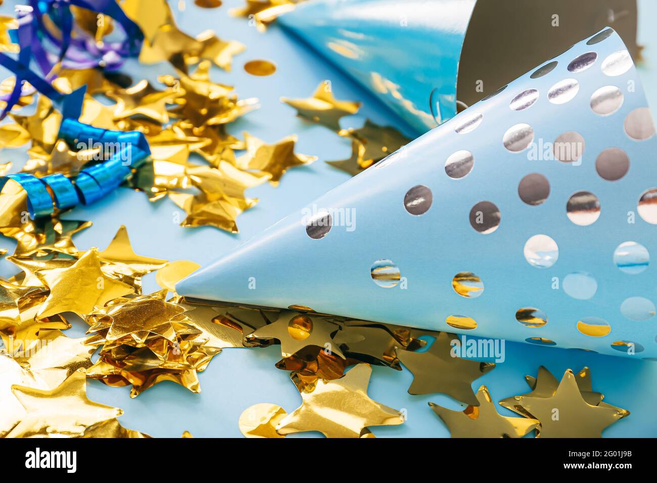 Party cones and confetti on color background Stock Photo - Alamy