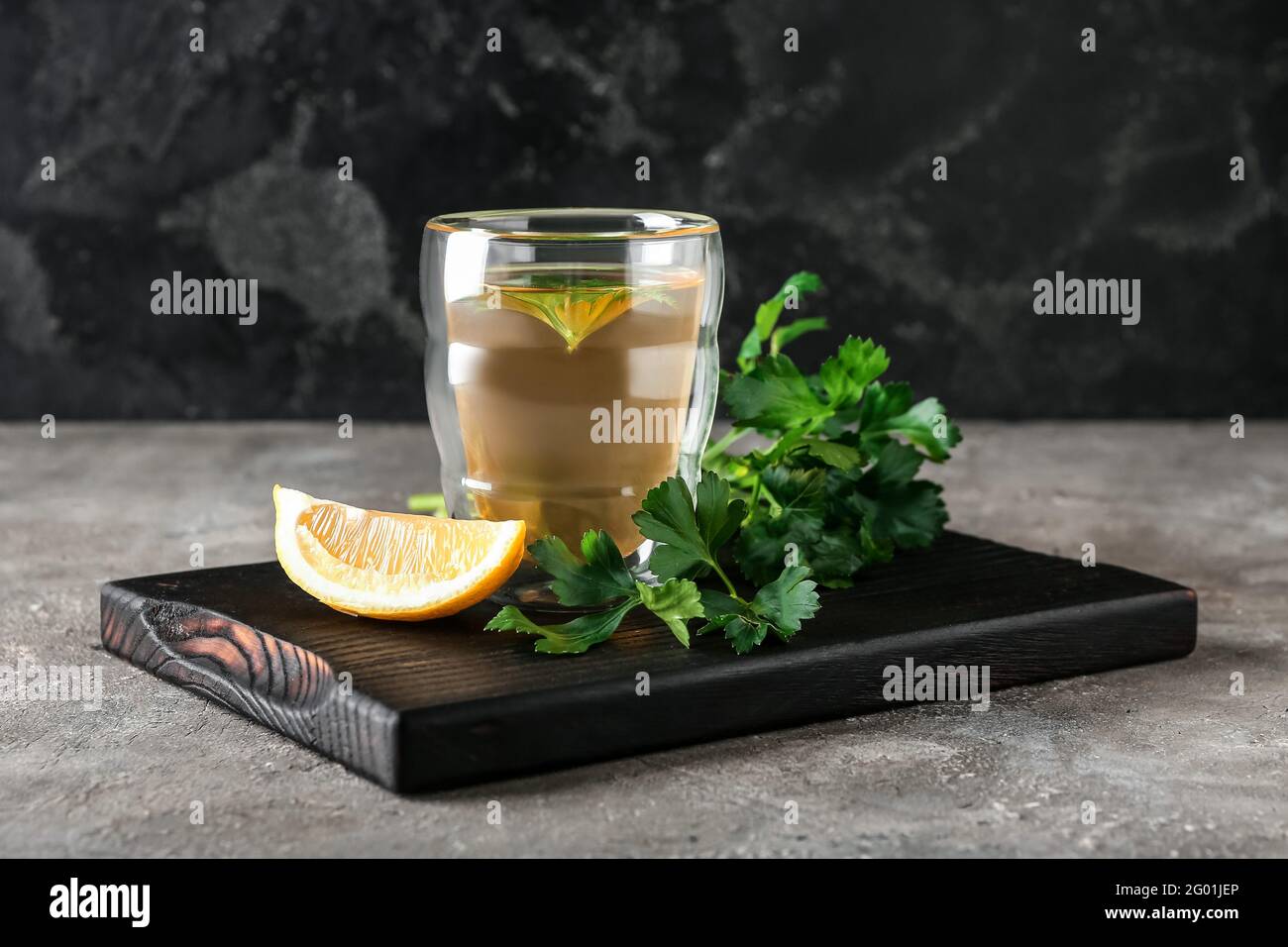 Board with cup of hot tea, parsley and lemon on grunge background Stock ...