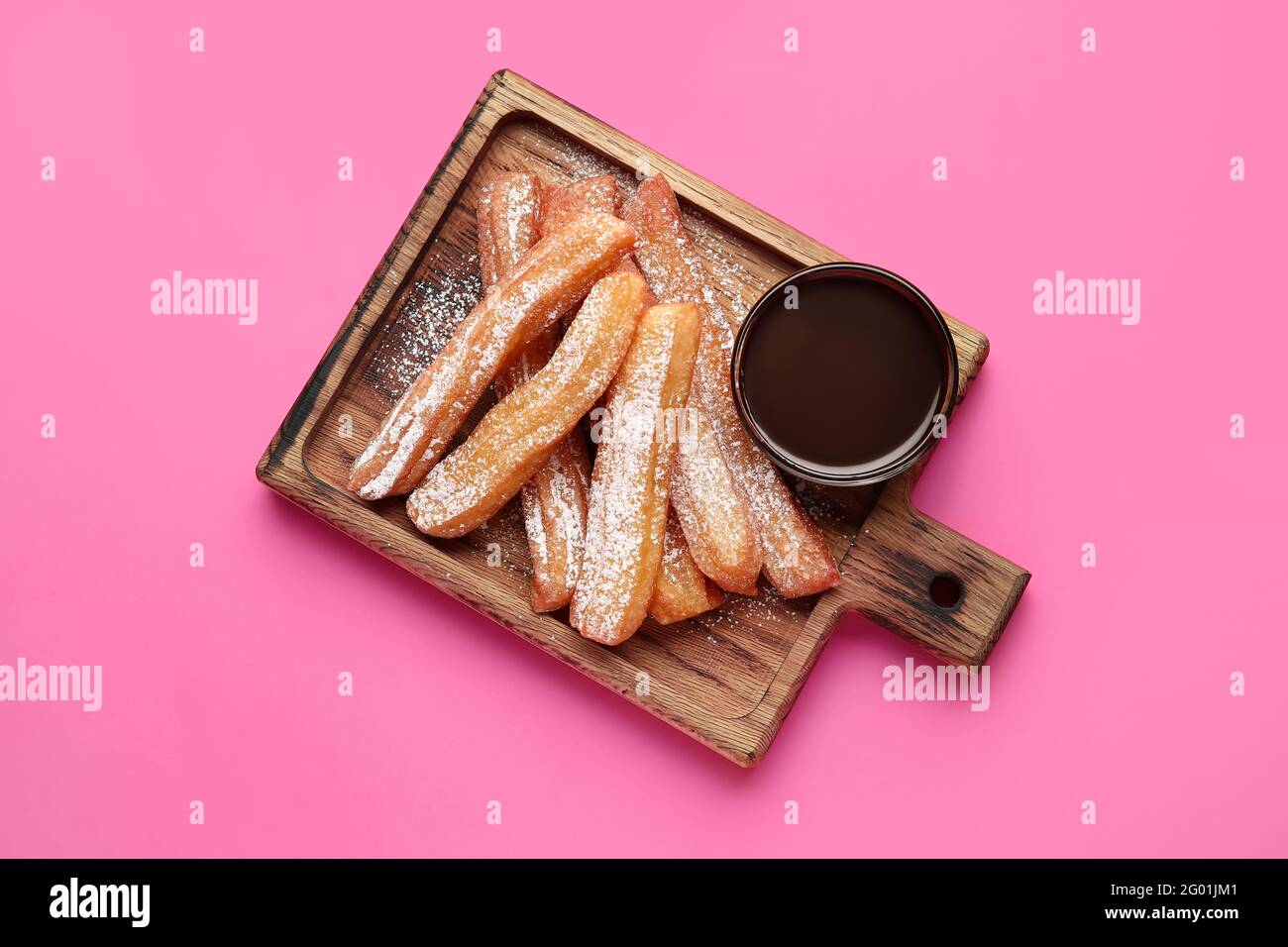 Board with tasty churros and melted chocolate sauce on color background ...
