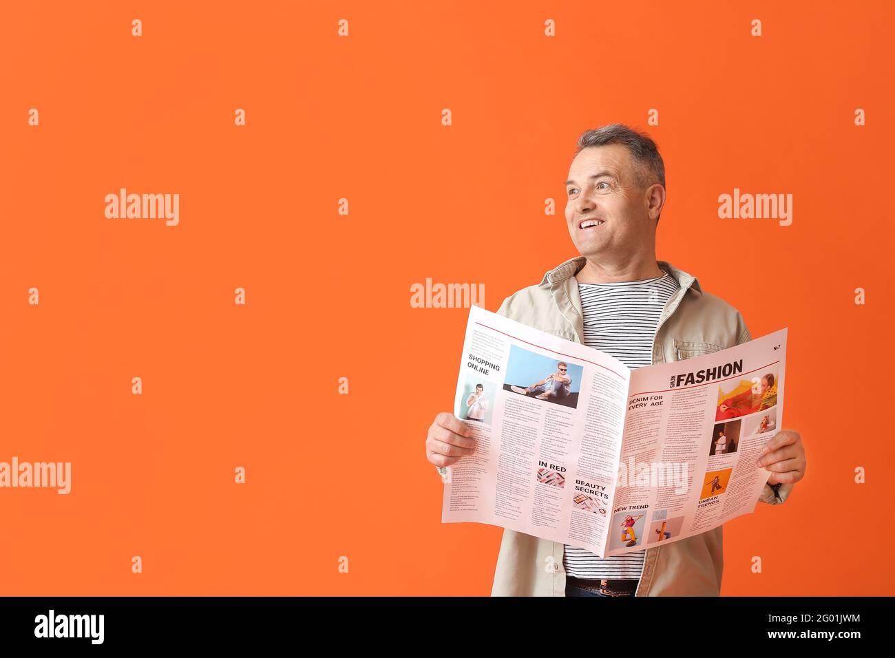 Mature man with newspaper on color background Stock Photo - Alamy