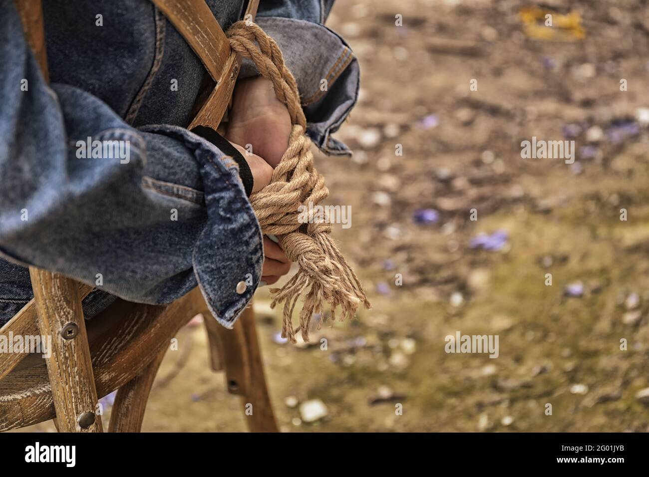 Female hostage sitting on chair outdoors Stock Photo - Alamy