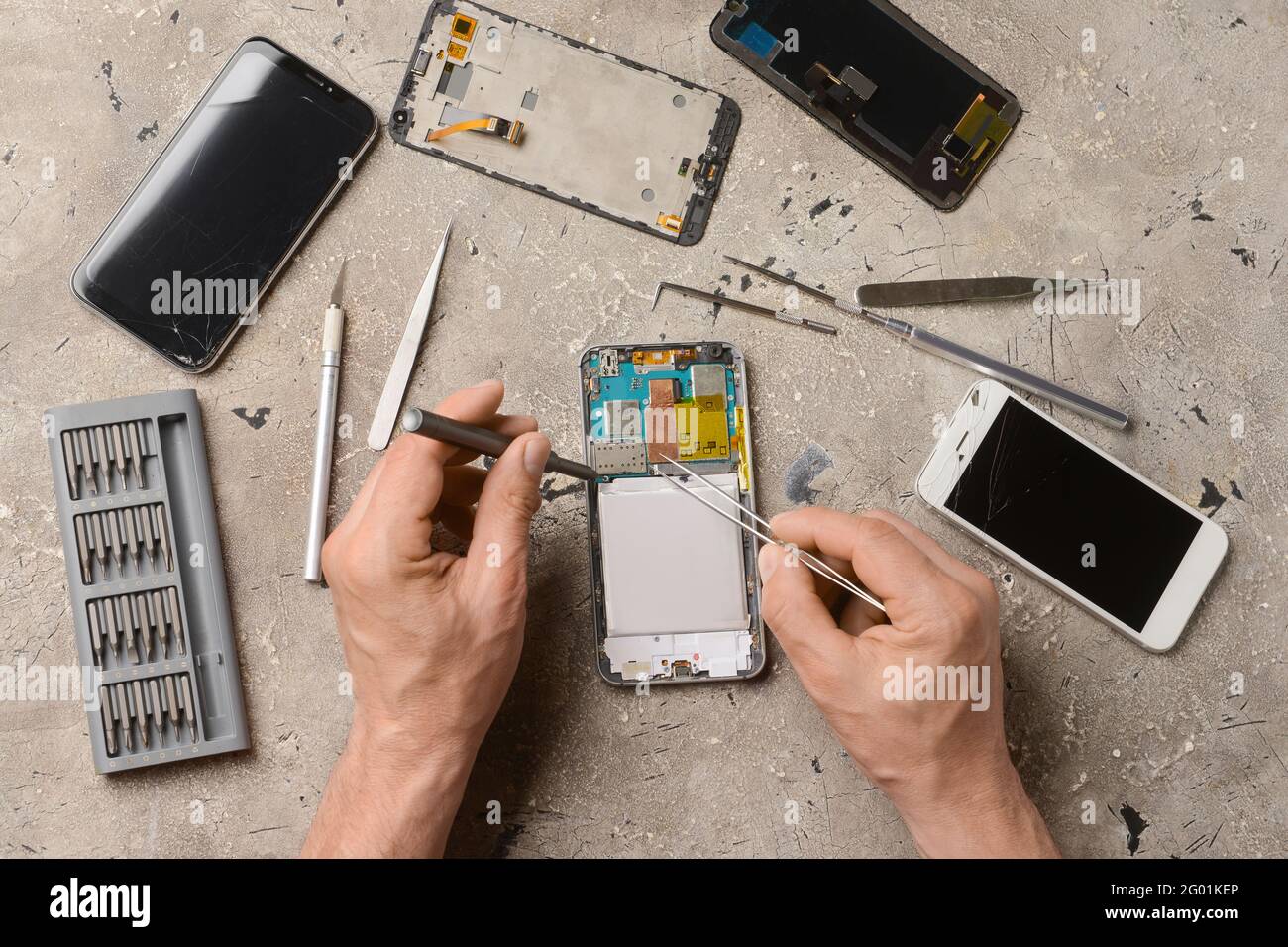 Male technician repairing damaged mobile phone on grunge background ...