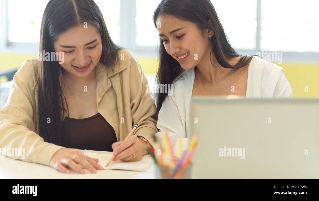 Portraits of two female students talking to each other about their ...