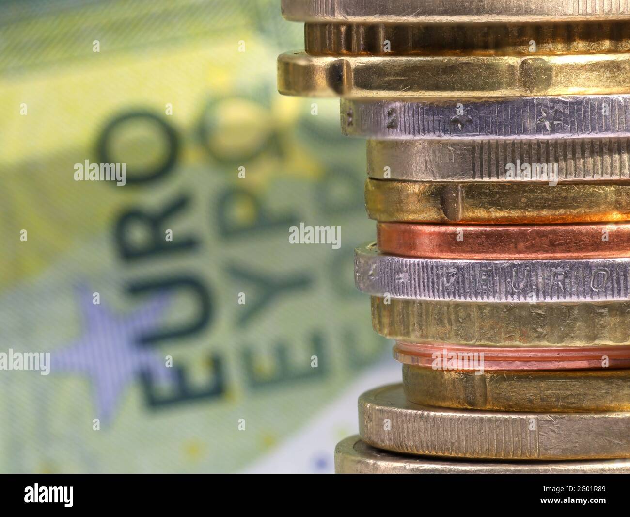 stacked euro coins close-up in front of hundred euro banknote, concept ...