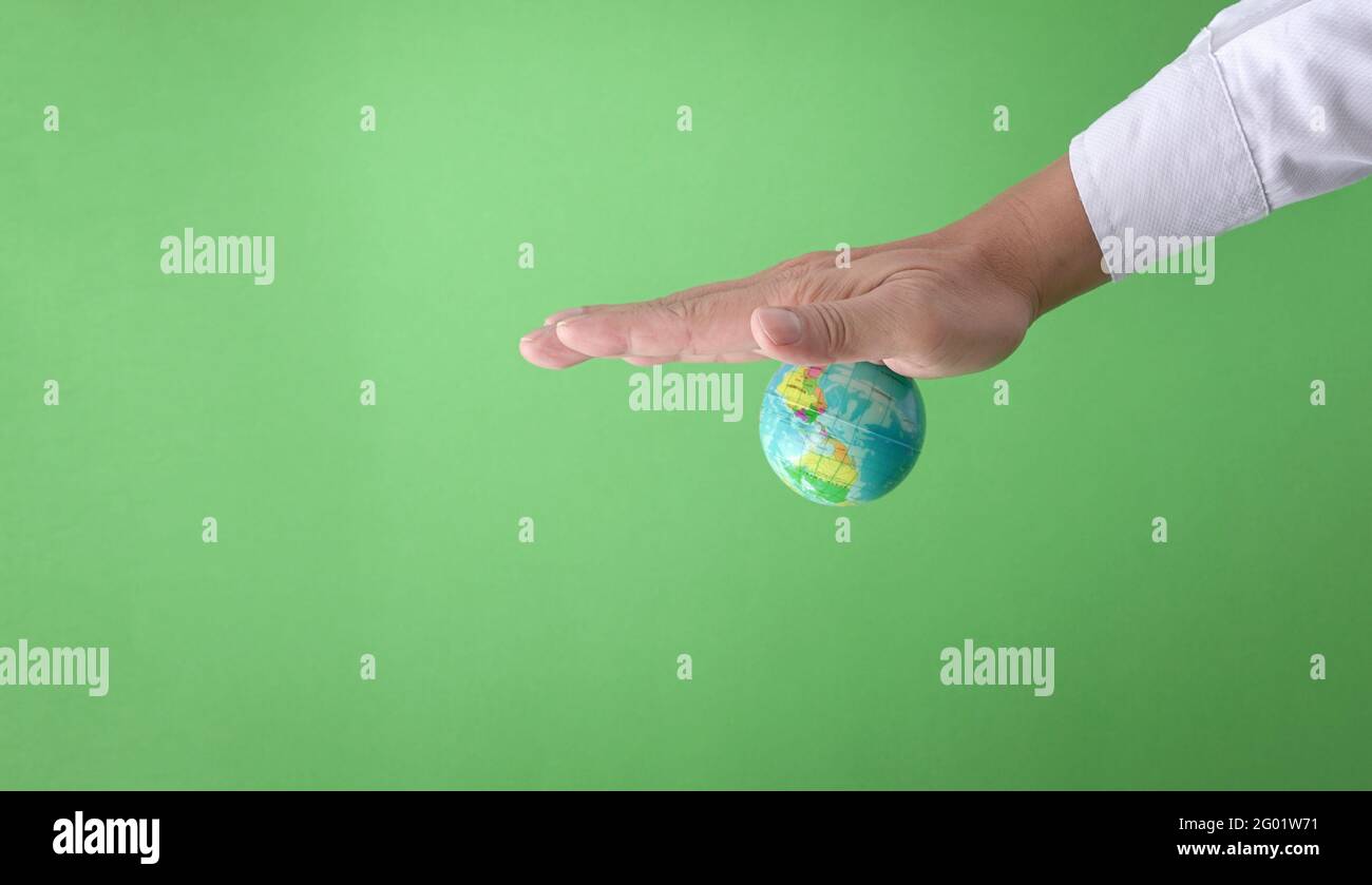 Businessman with the globe stuck to his palm, Green background. Human ...