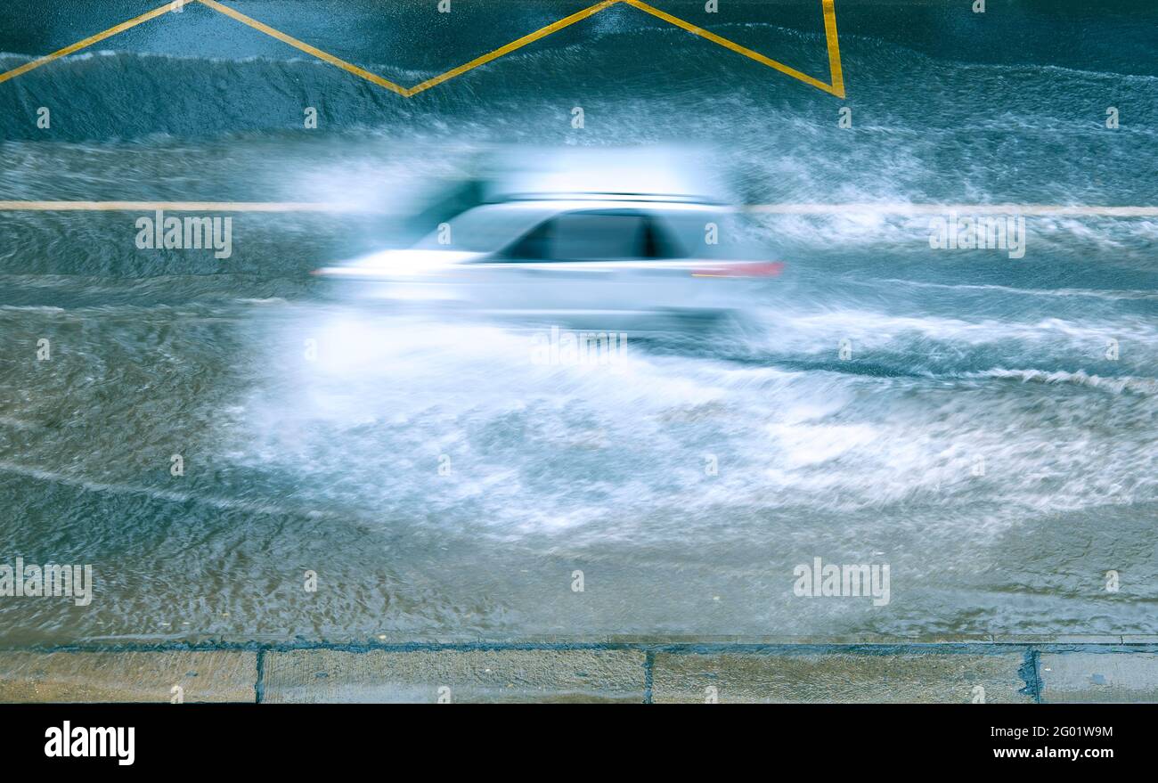 Heavy flood in the city, car motion with fast speed on the big puddle ...