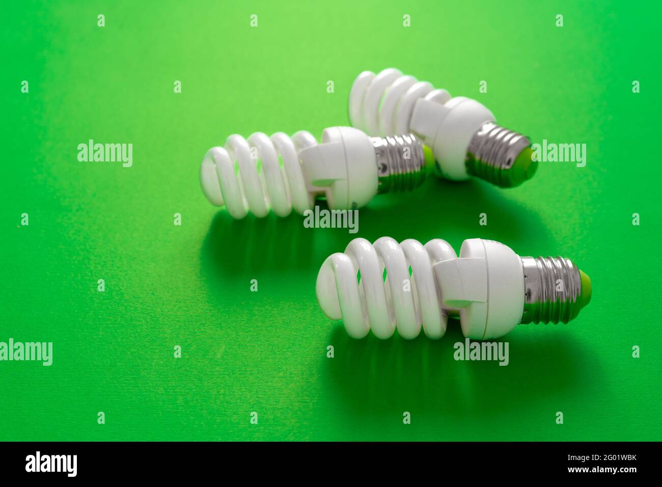 Light bulb on green paper background close up Stock Photo - Alamy