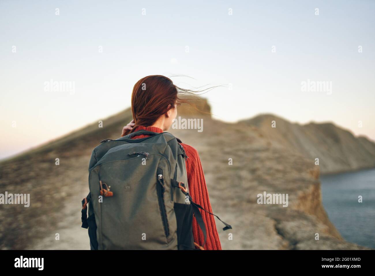 woman turned back and mountains in the distance travel tourism backpack ...