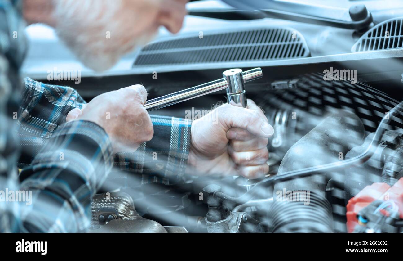 Car mechanic repairing a car engine; light effect Stock Photo - Alamy