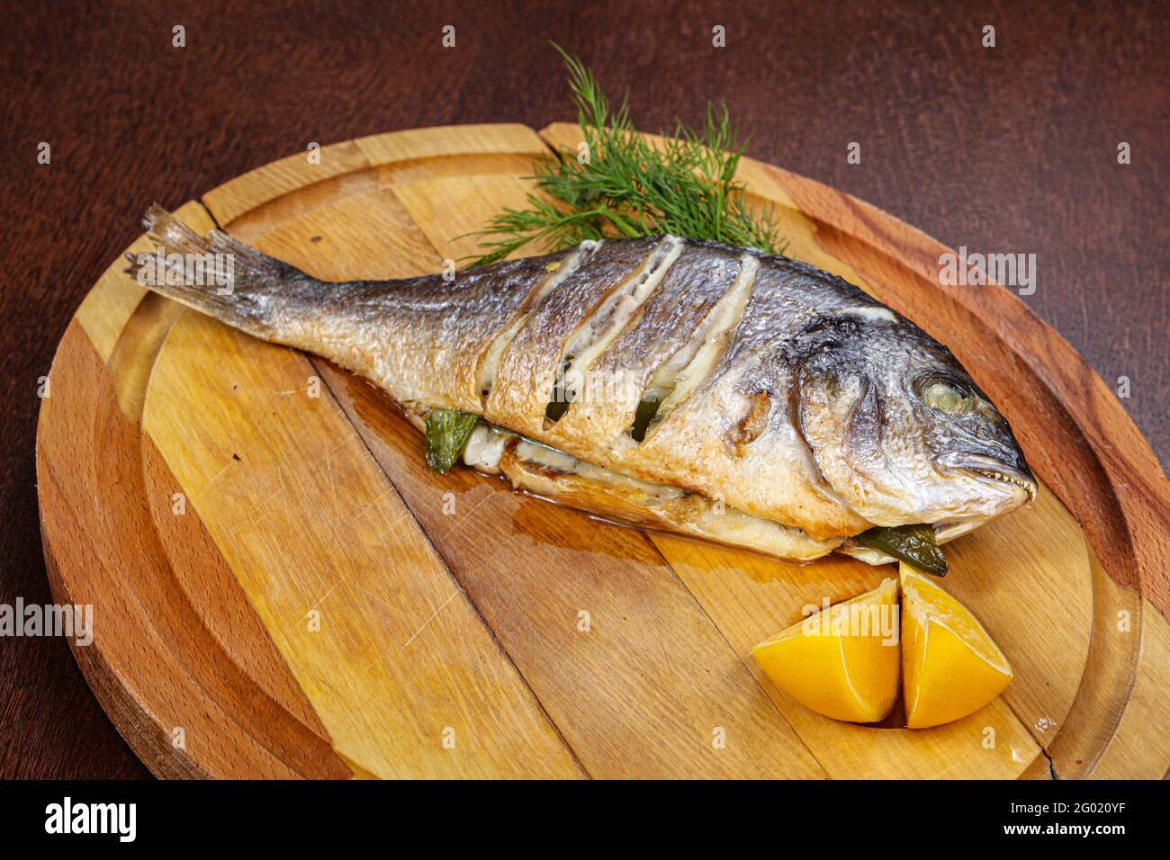 Baked dorado fish served lemon and dill Stock Photo - Alamy