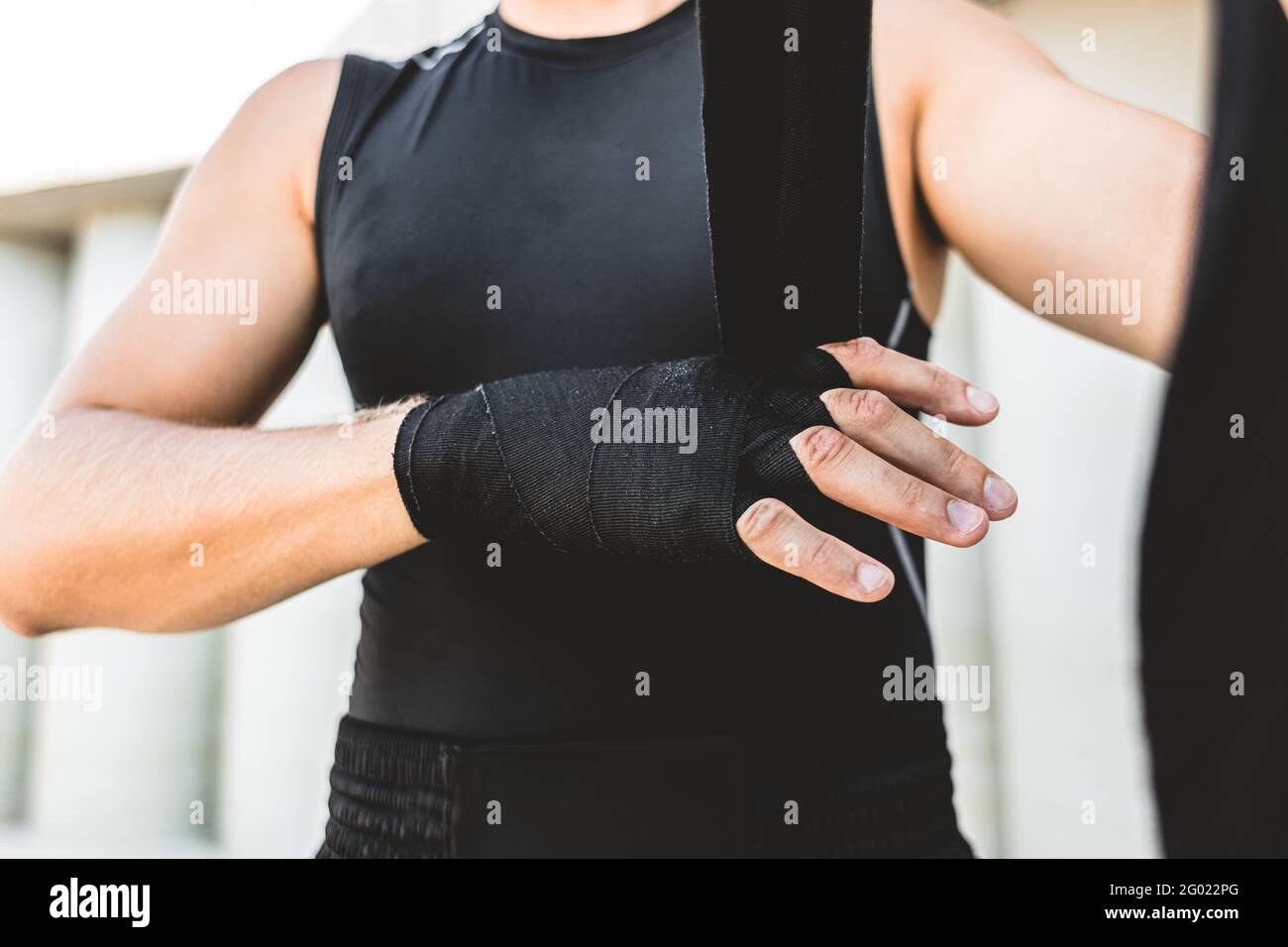 Boxer wrapping up his hands boxing bandages before a match, fight or ...