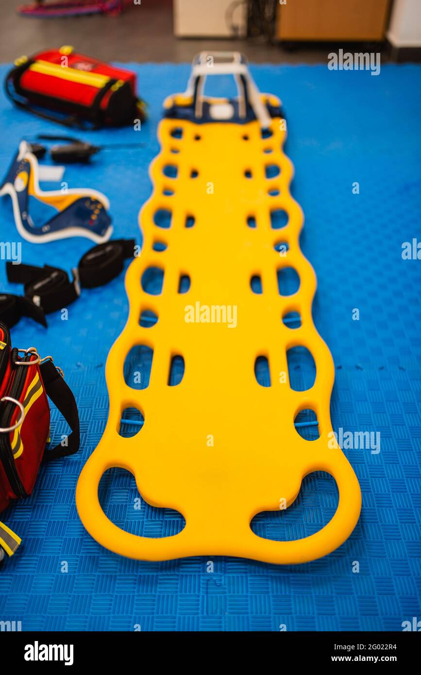 Yellow first aid stretcher on a blue background. First aid equipment ...