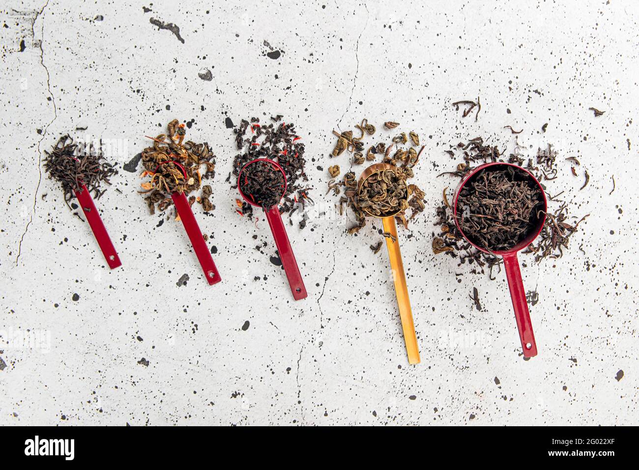 Set of different dry tea in measuring spoons Stock Photo - Alamy