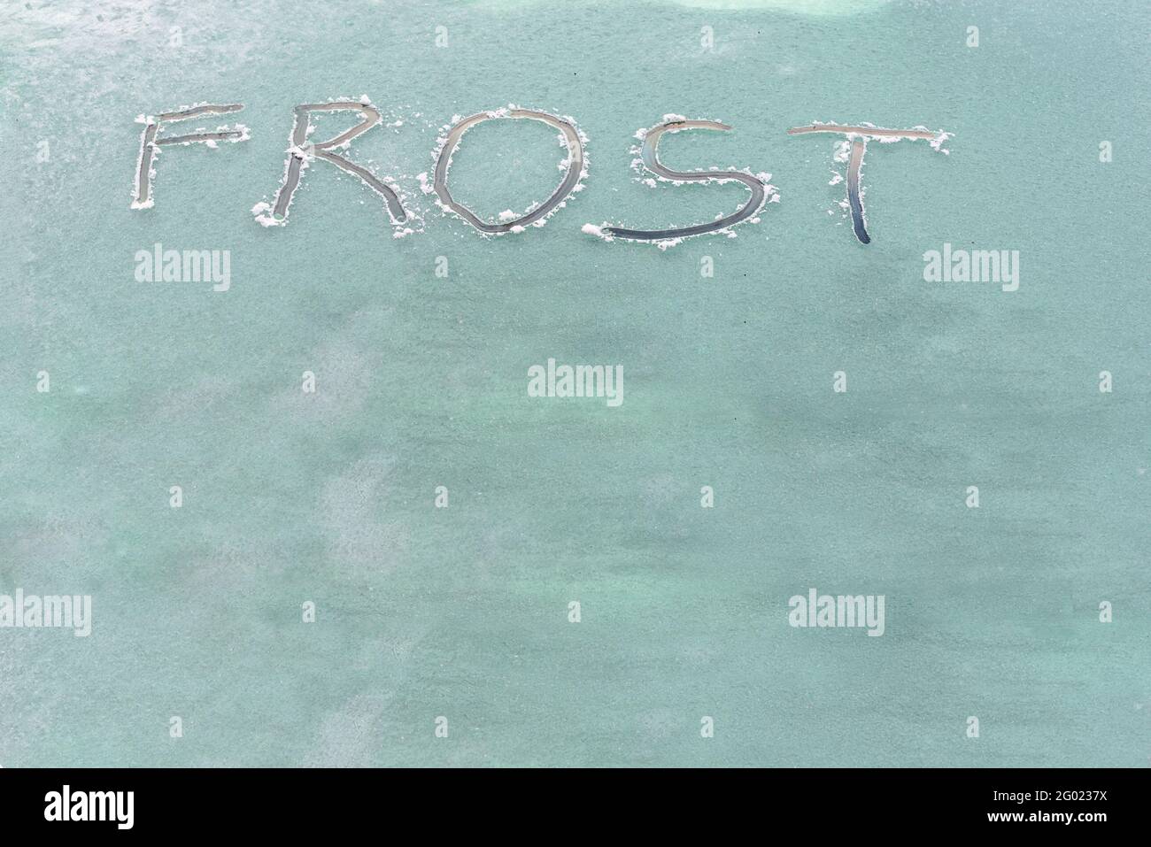 Iced frosted window, frost on glass, ice in winter, texture with text ...