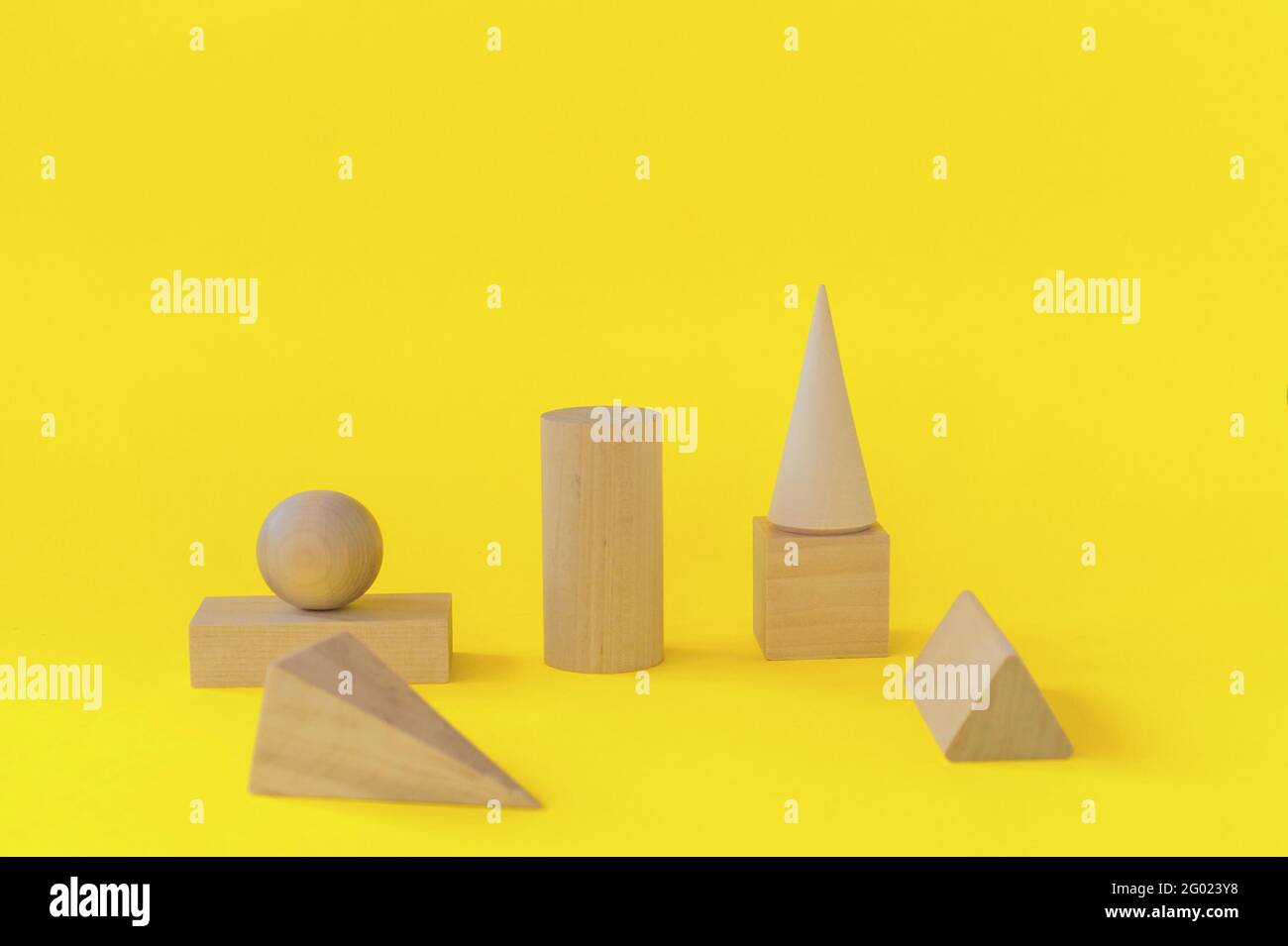 wooden geometric shapes on a yellow background. preschool learning ...