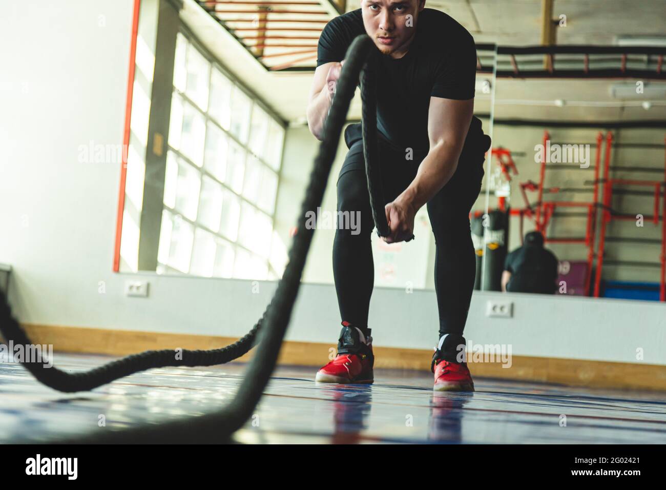 Muscular attractive man in the gym with ropes doing exercises. Crossfit ...
