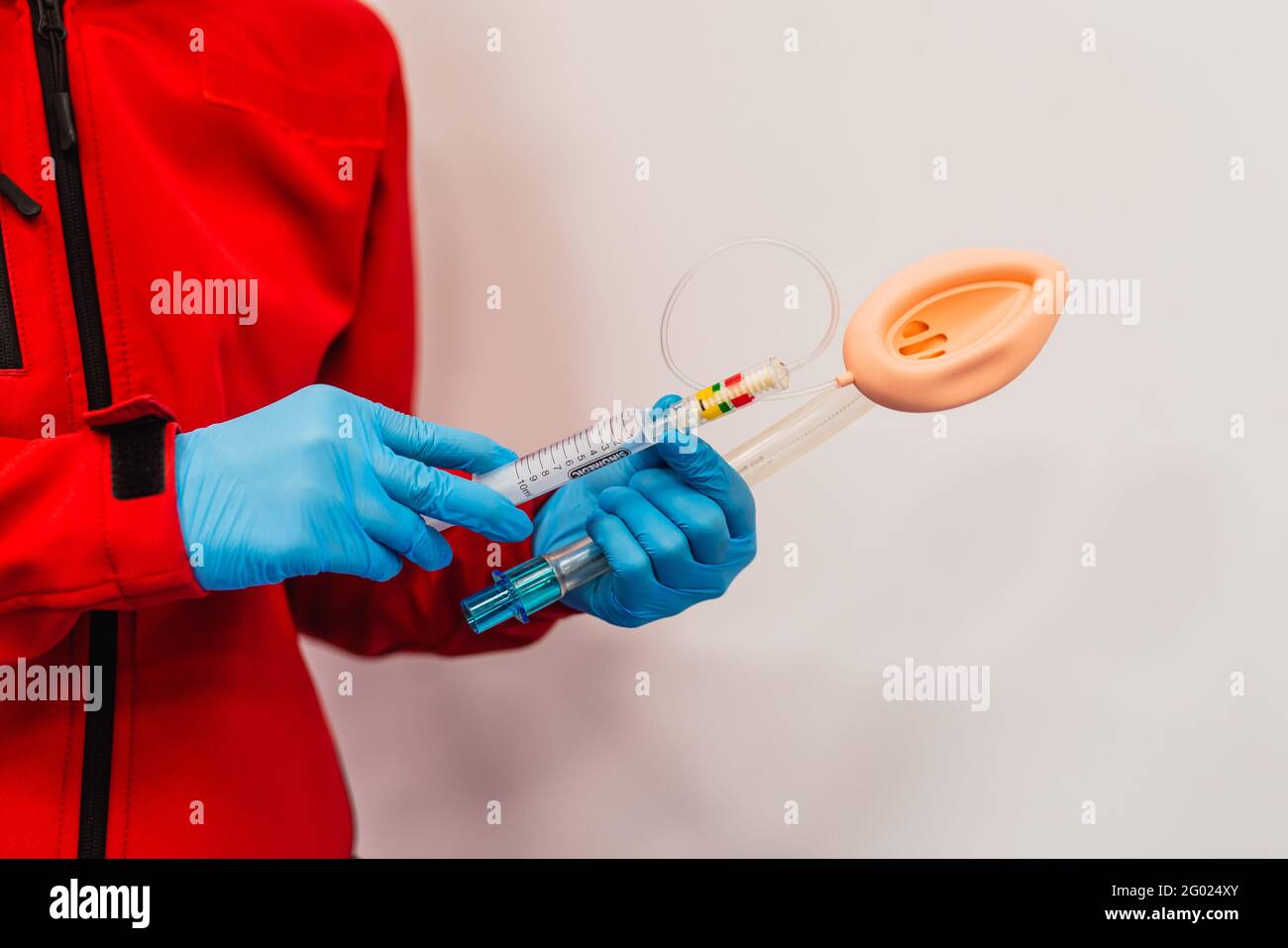 A doctor in a red uniform holds intubation equipment, close - up, a ...