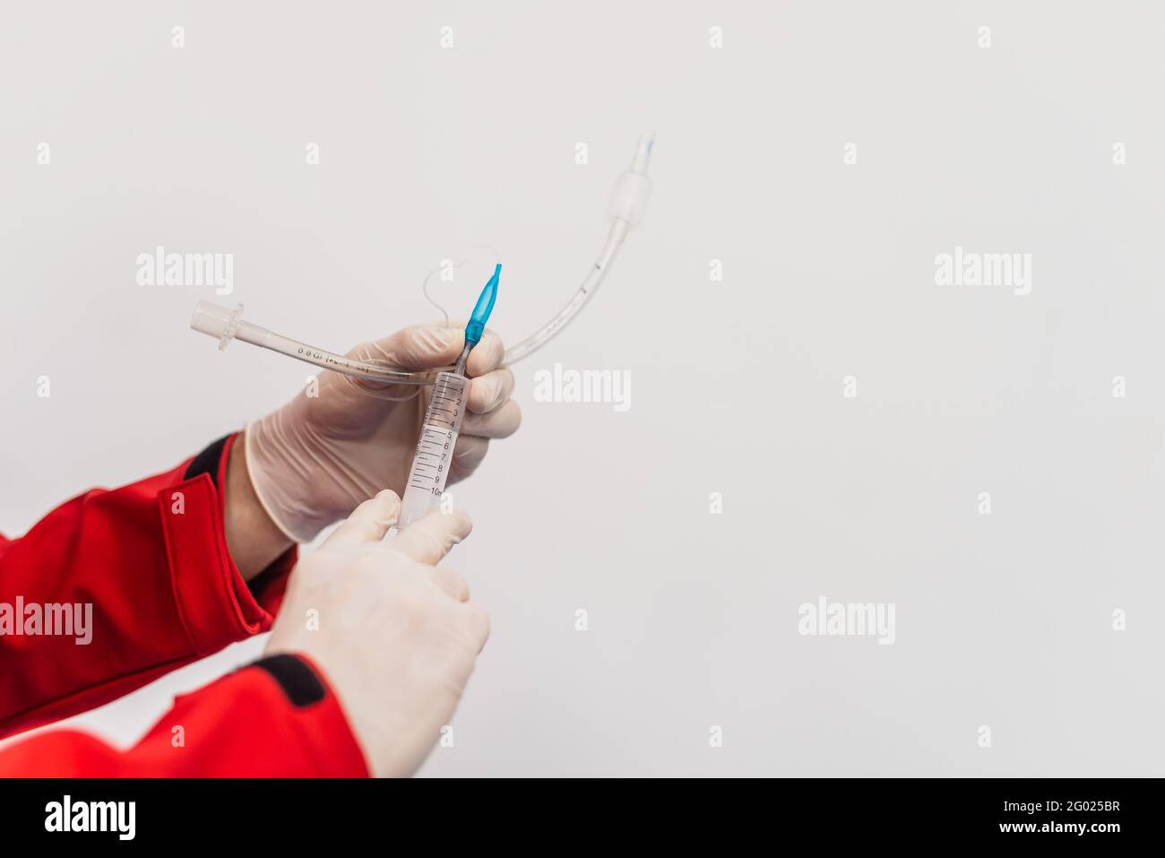 The paramedic holds intubation equipment, closeup, white background ...
