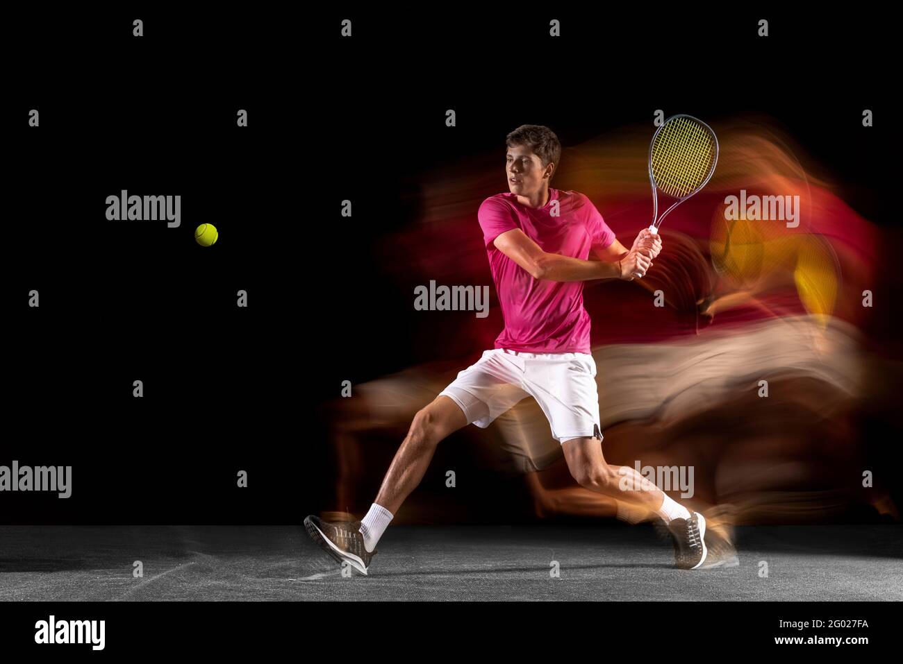 One man, male tennis player training isolated in mixed neon light on ...