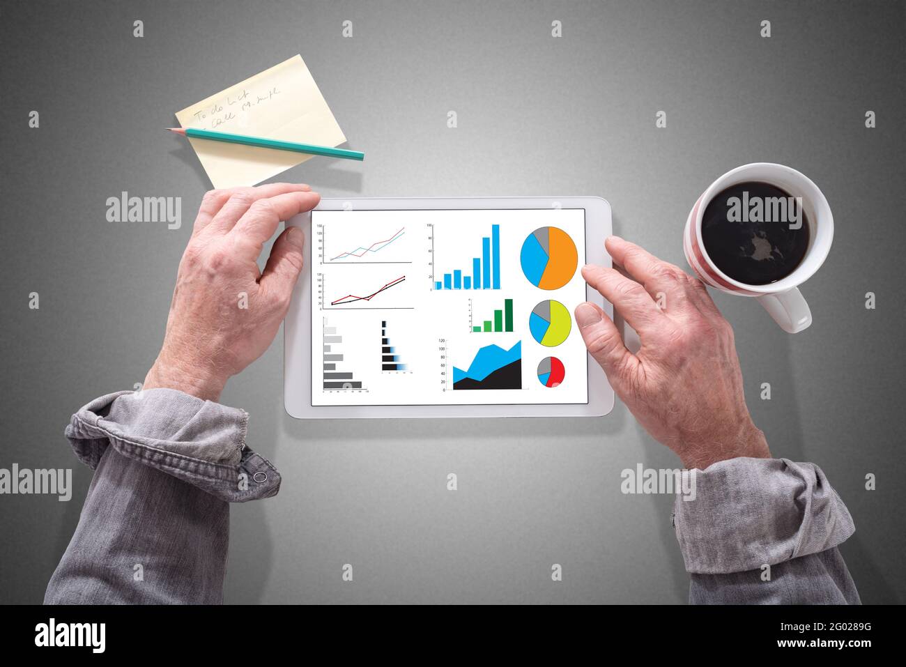 Male hands using a tablet showing graphical analysis concept Stock ...