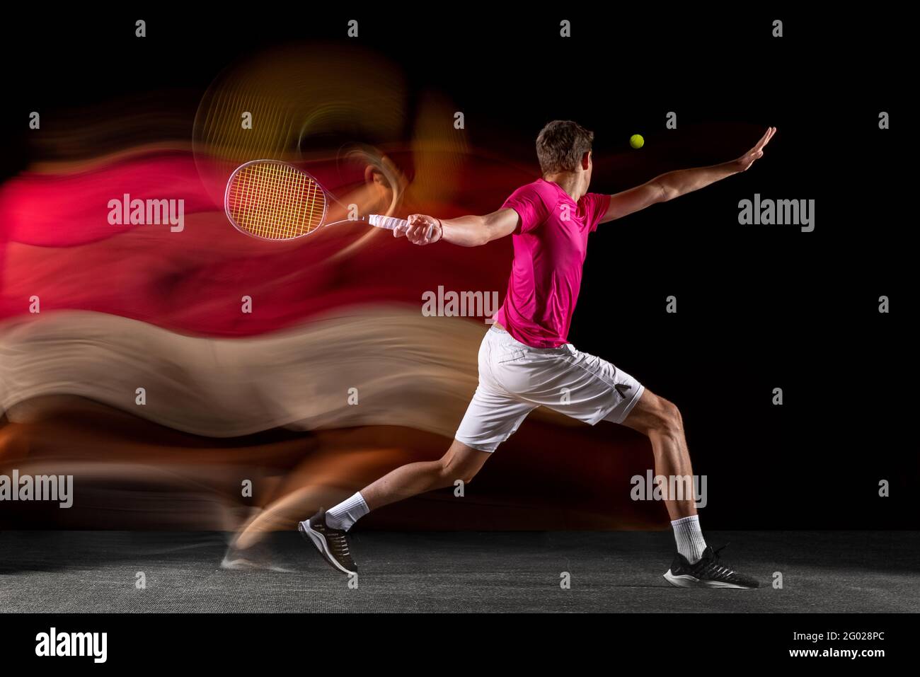 Young caucasian male tennis player playing tennis in mixed light on ...