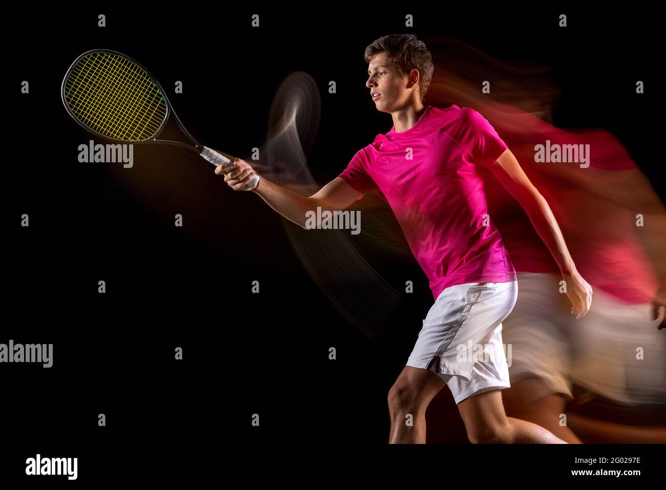 One man, male tennis player training isolated in mixed neon light on ...