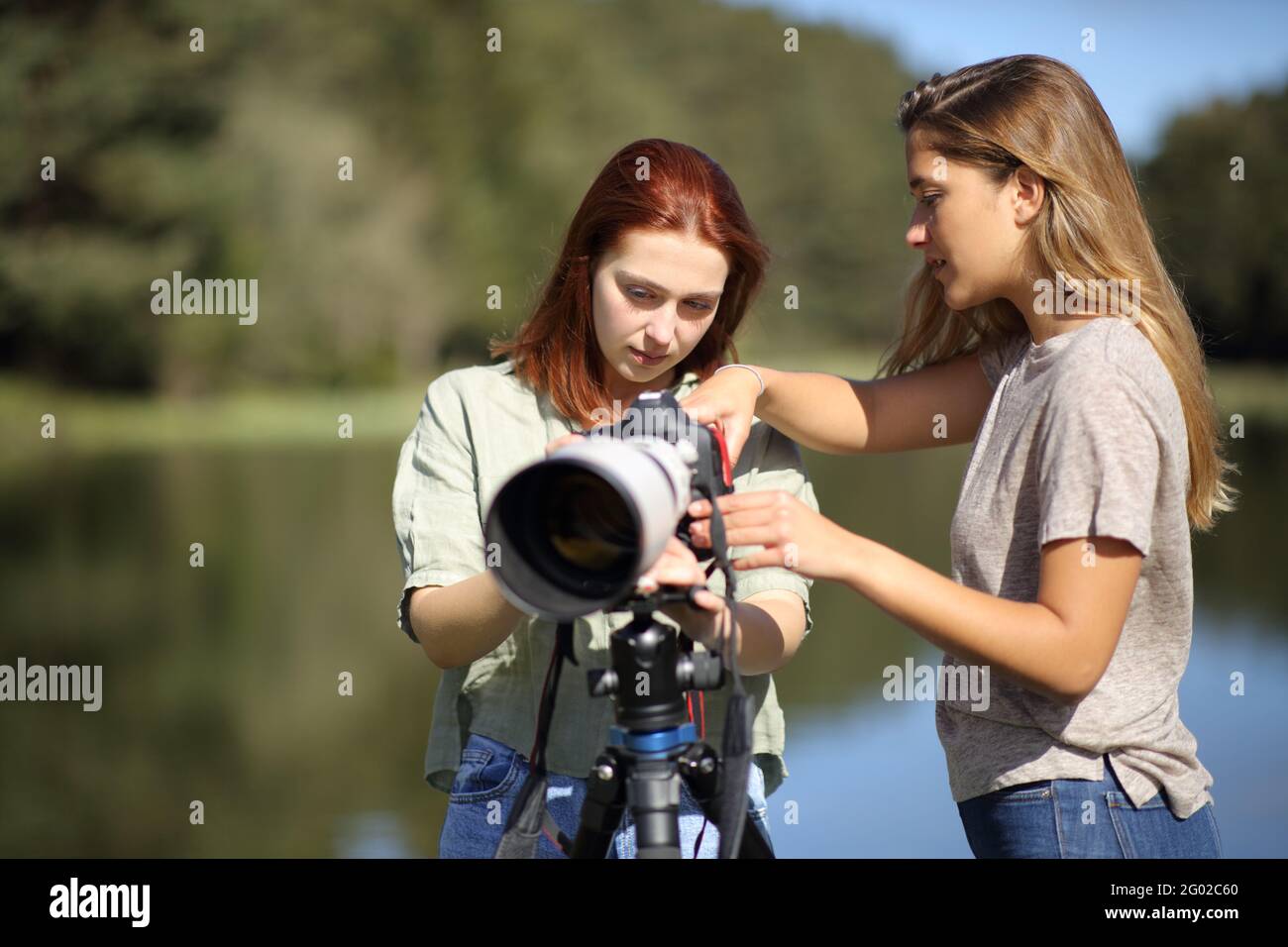 Photography teacher teaching to a student how to use a dslr camera in ...