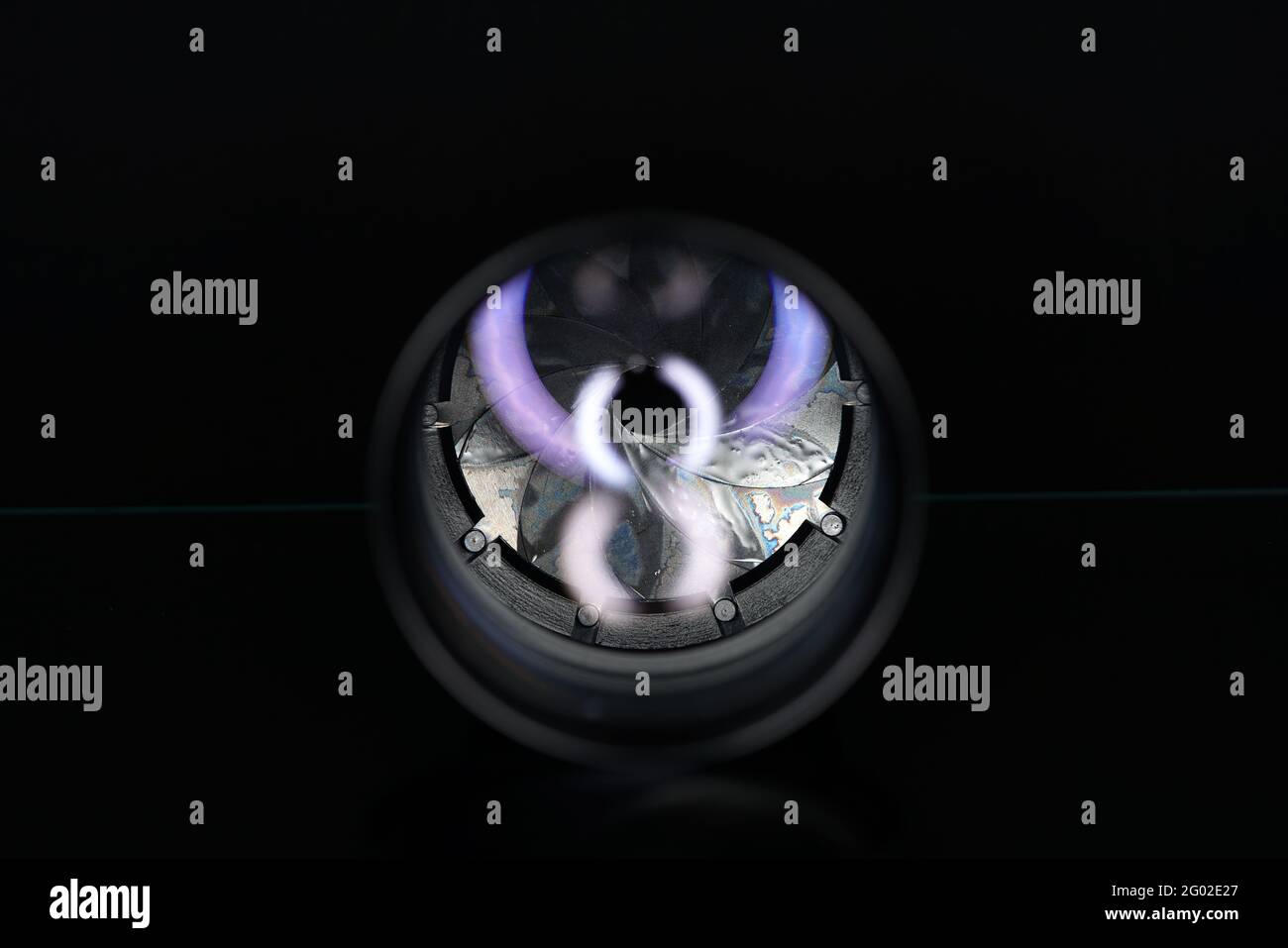 Optical lens of a camera with a dim glowing number 8 in front of it in ...