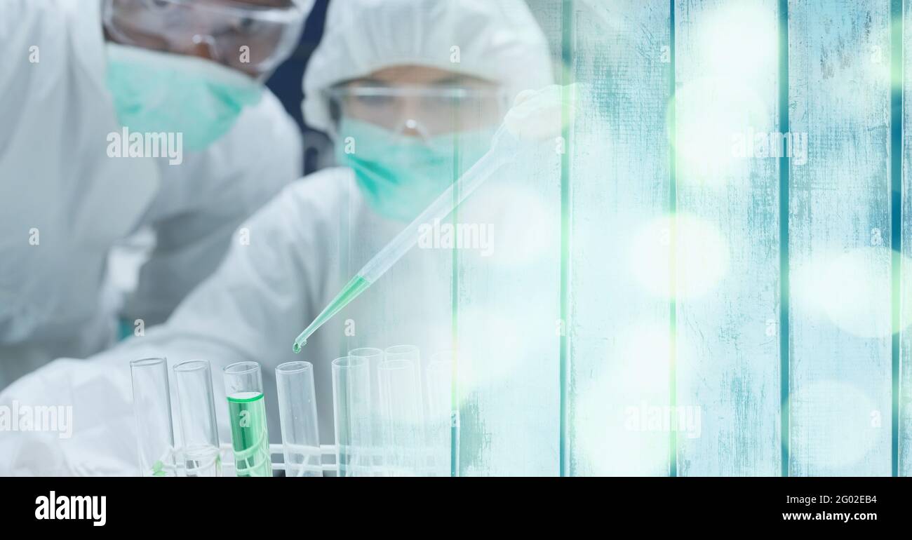 Composition of scientists in ppe suits with test tubes working in ...