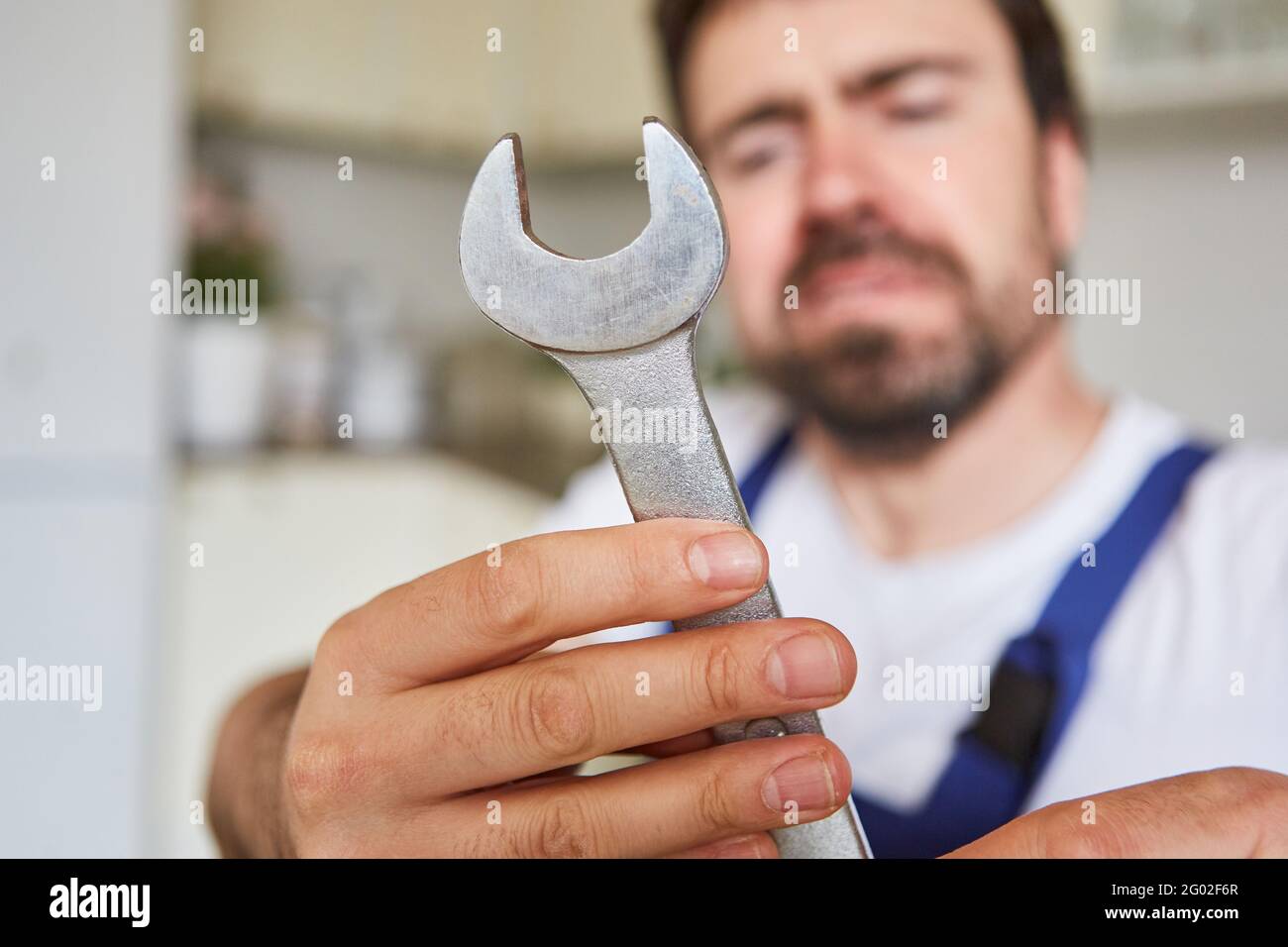 Installer from the emergency service holds an open-end wrench for ...