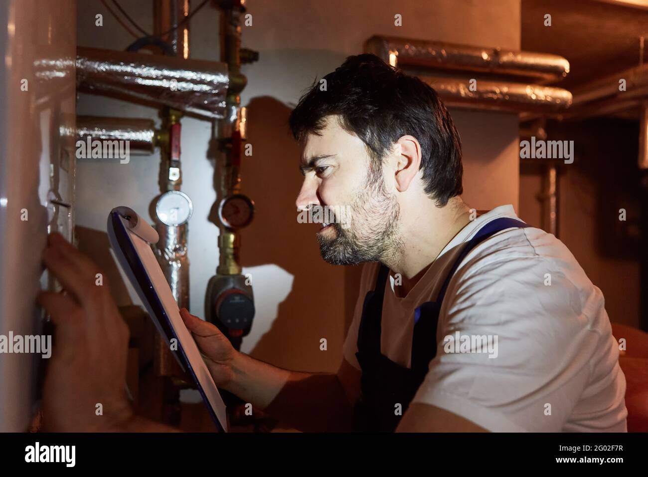 A heating installer or fitter uses a checklist to check the heating ...