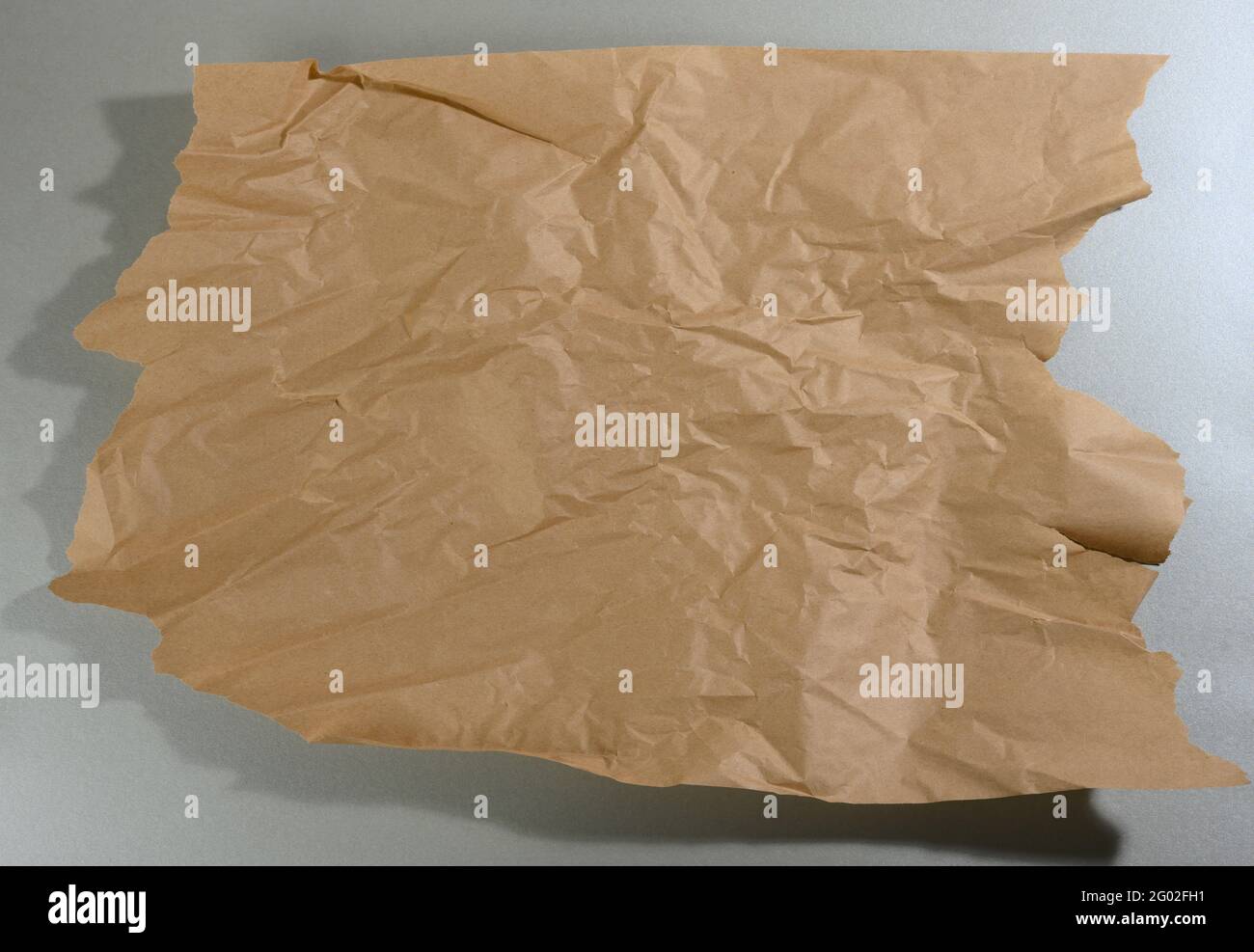 mint brown piece of paper with torn edges and shadow on gray background ...