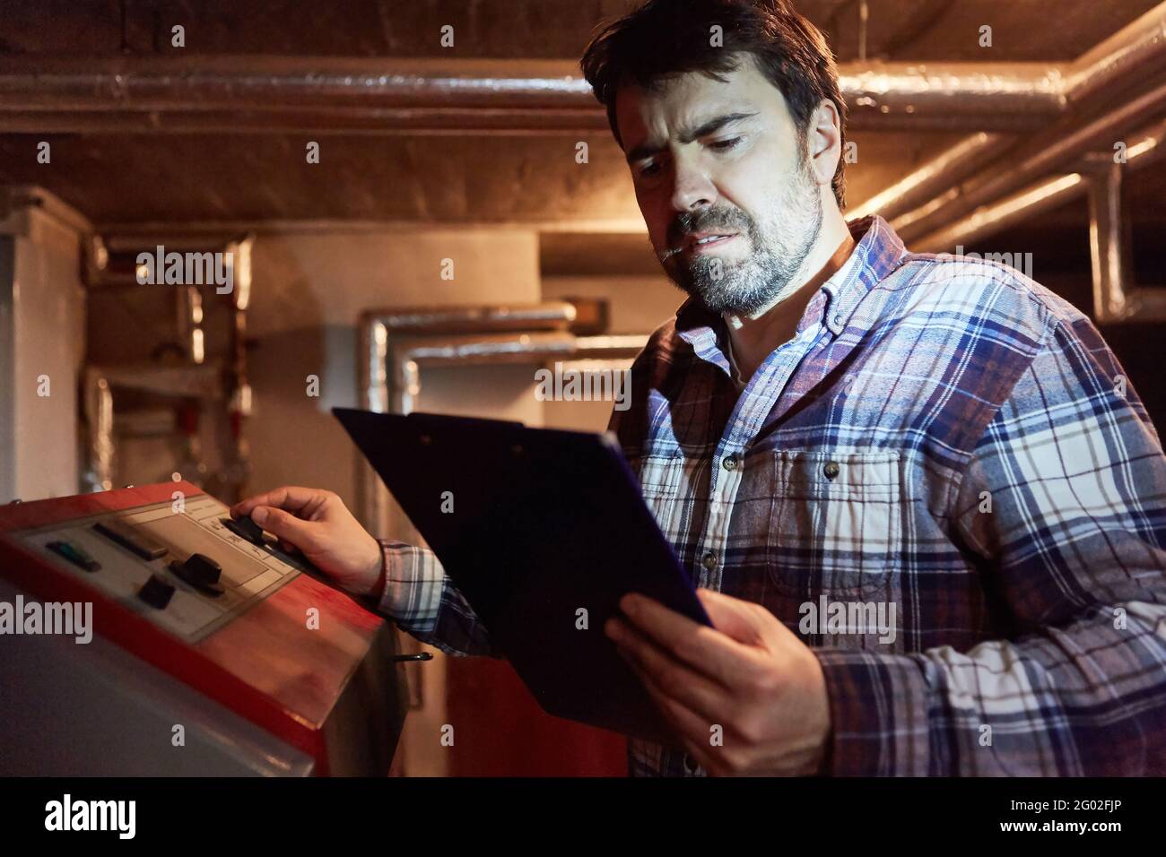 A heating fitter checks the gas heating condensing boiler during ...