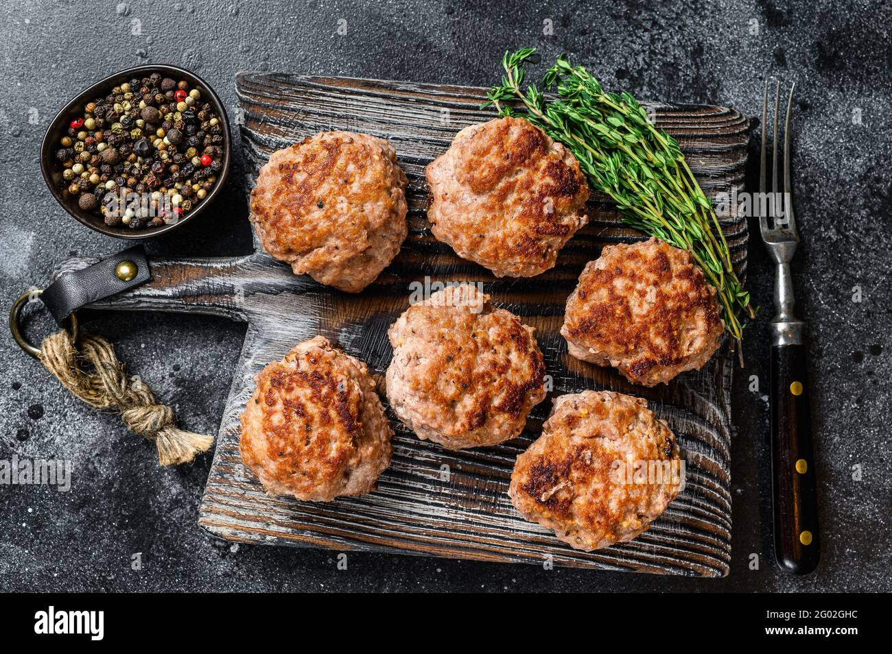Roasted cutlets from beef and pork meat. Black background. Top view ...