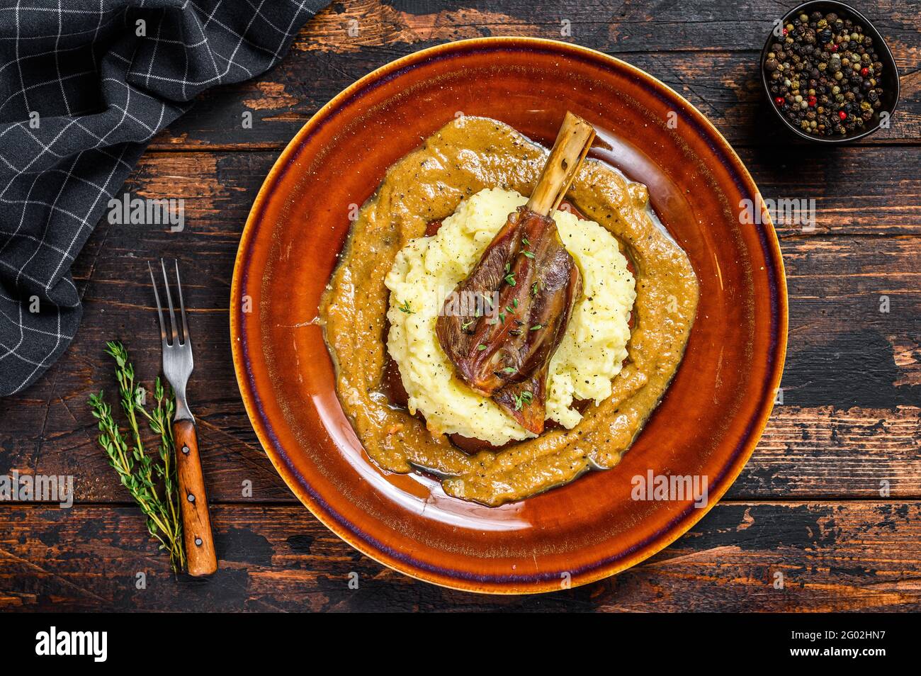 Stew goat Shanks with mash potato on a plate. Black background. Top ...