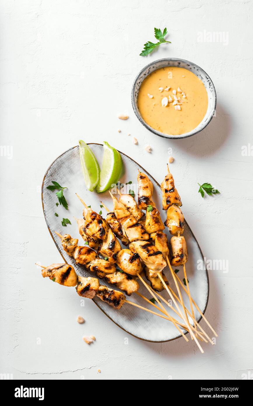 Chicken grilled satay skewers served with lime and peanut sauce on ...