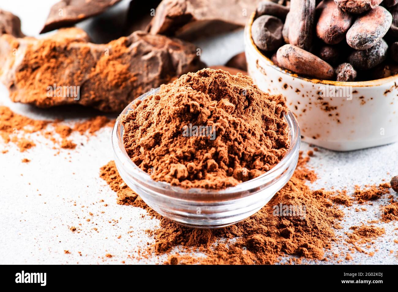 Organic cocoa powder, beans, grated lump on gray background. Copy space ...