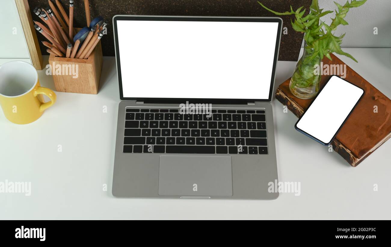 Mock up laptop computer and smart phone with blank screen on office ...