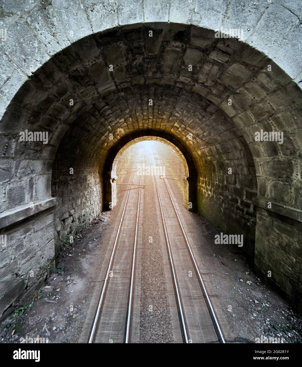 Dark passageway of roughly hewn stones with a round arch through which ...