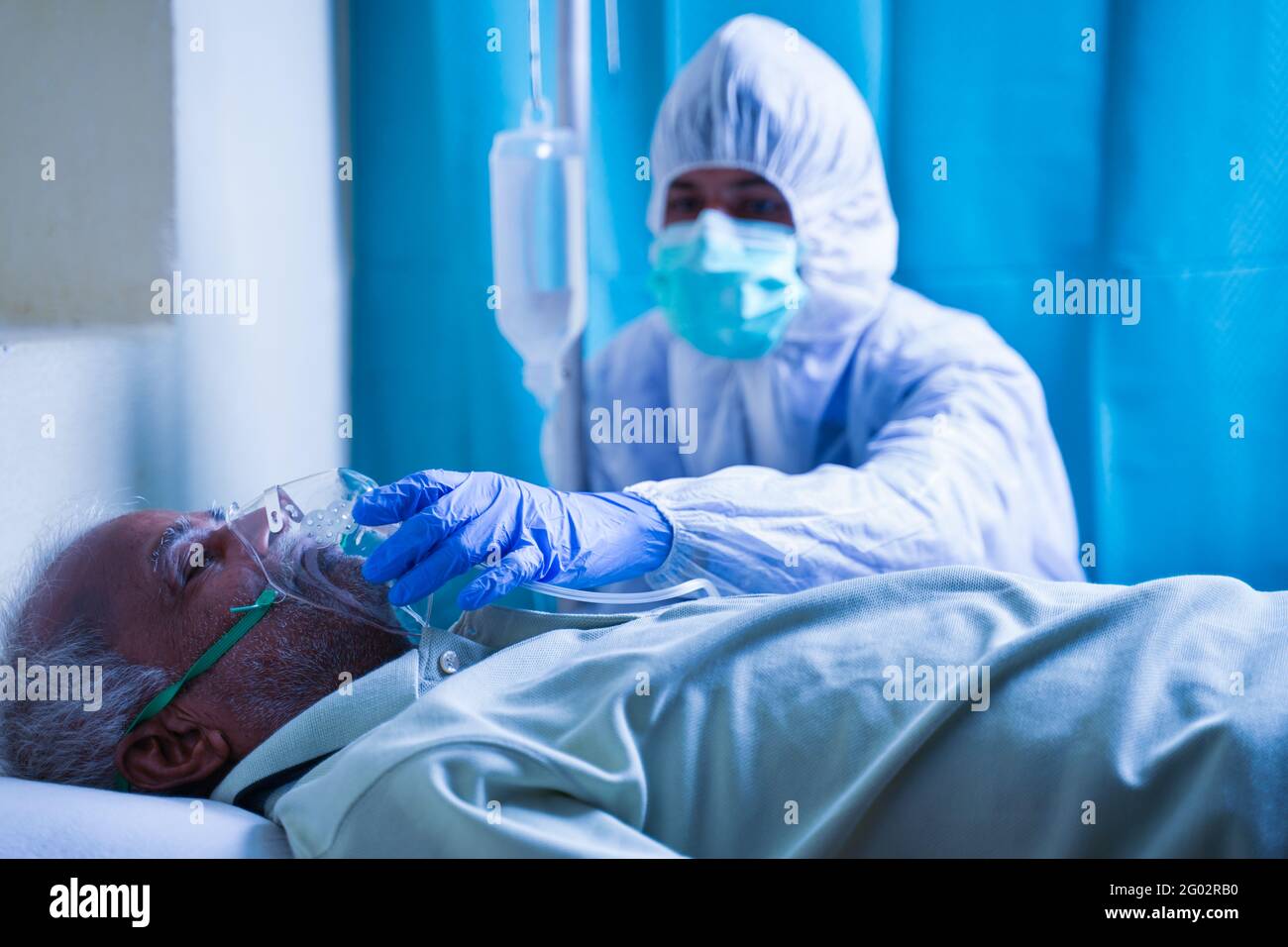 Doctor hazmat or protective suit helping to wear ventilation oxygen ...