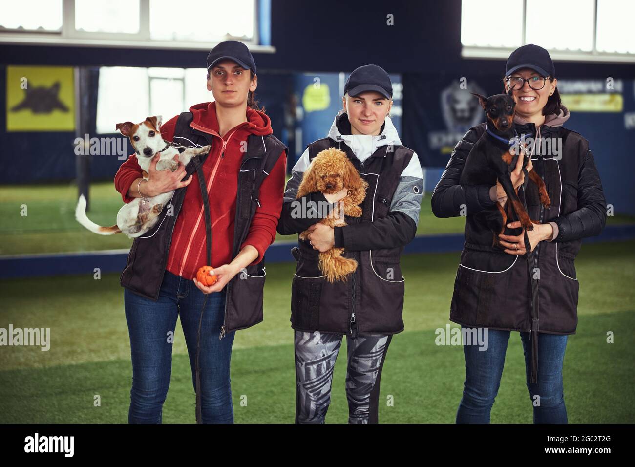 Three professional dog handlers posing for the camera Stock Photo - Alamy