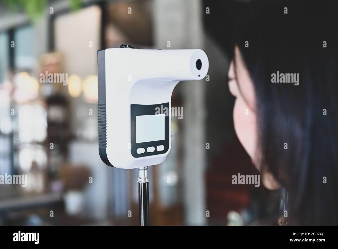 Office worker checking body temperature with infrared forehead ...