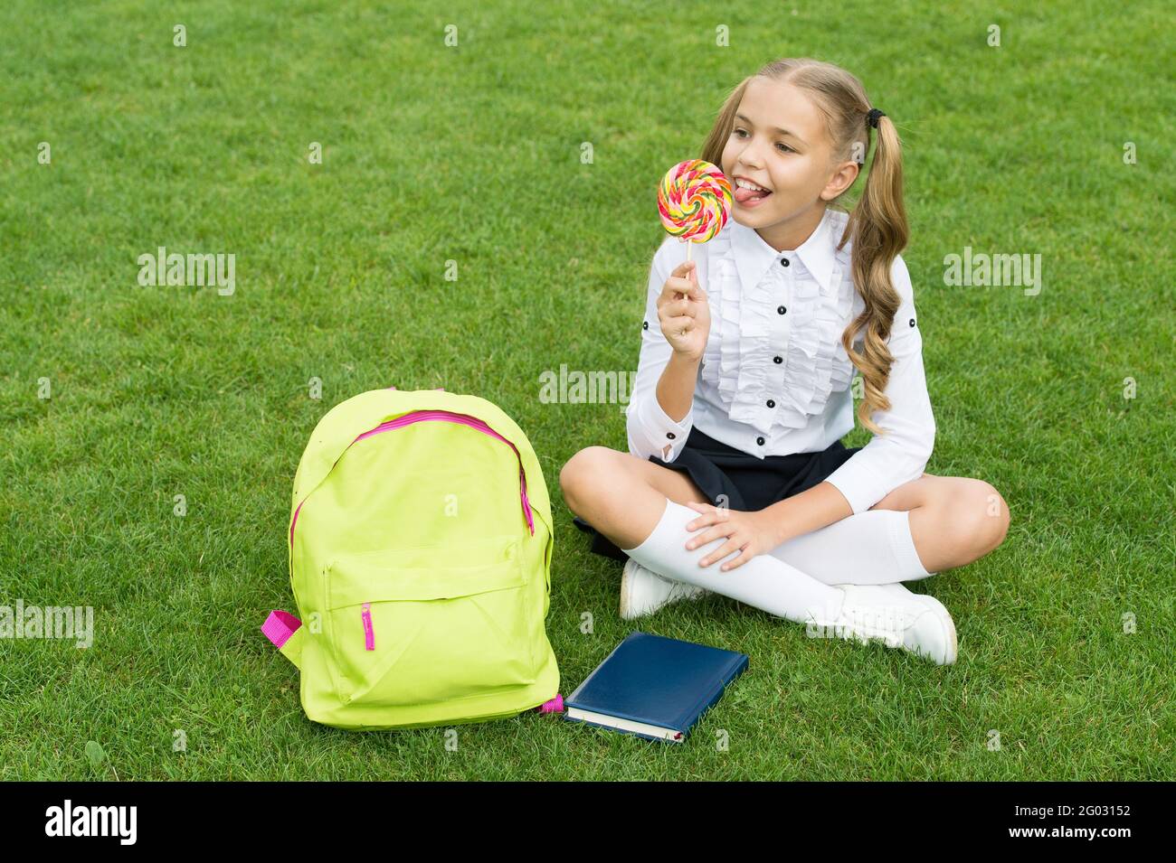 Candy kid. Happy schoolchild enjoy lollipop. Sweet tooth. Candy eating ...