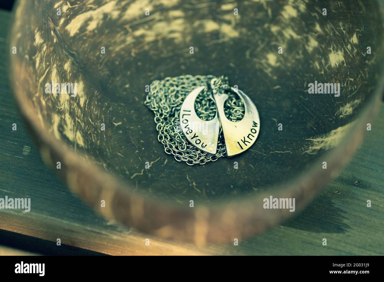 Couple set pendant necklace two half of a heart shoot outdoors in a sunny day closeup. Selective ...