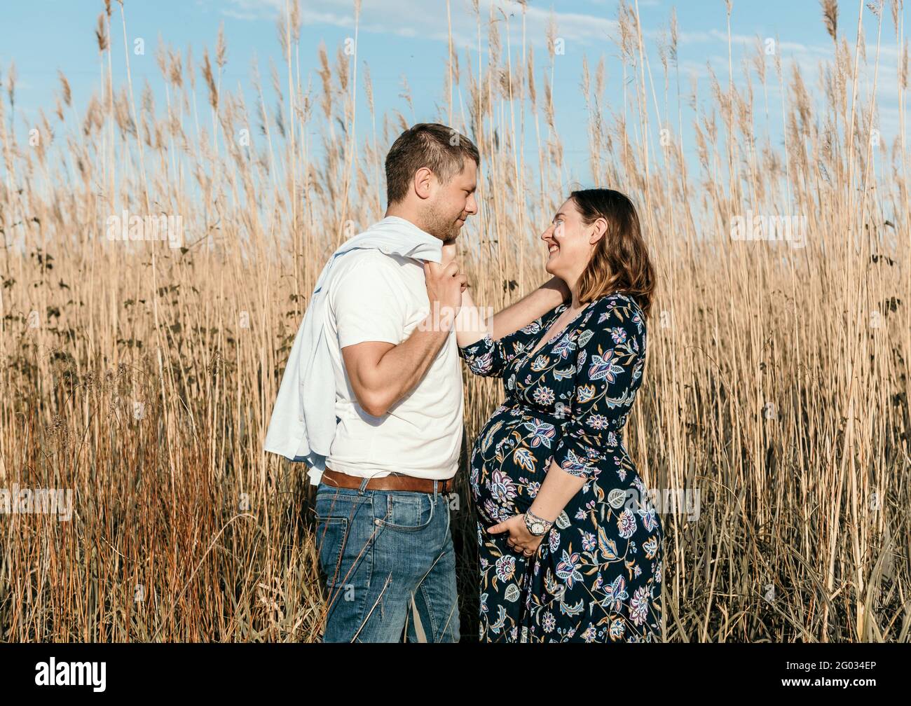 Beautiful young couple expecting a baby. Outdoor photo of happy parents ...