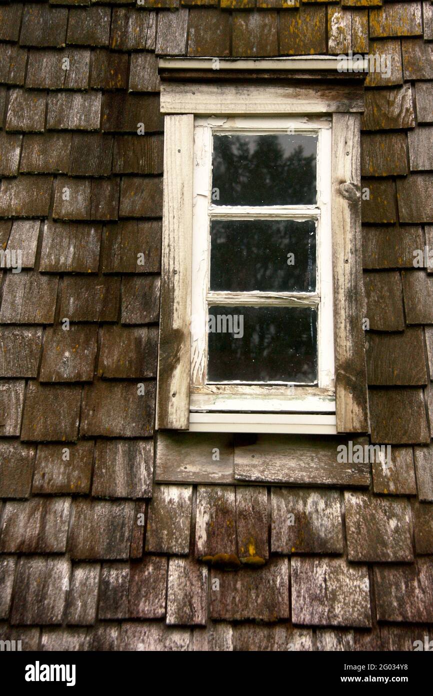 Michigan, USA. Small attic window of an old building with wooden ...