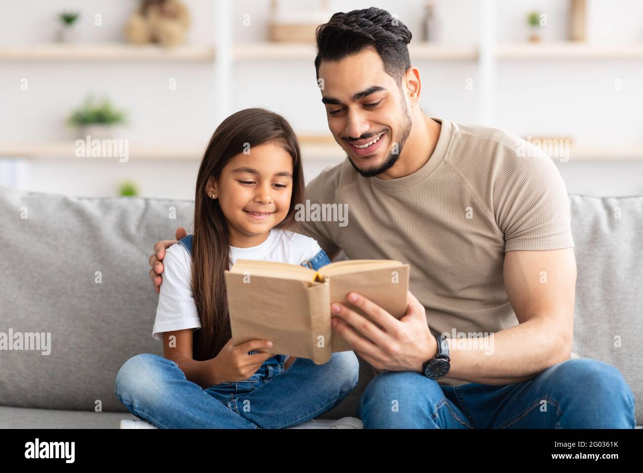 Dad and daughter reading book spending time together at home Stock ...