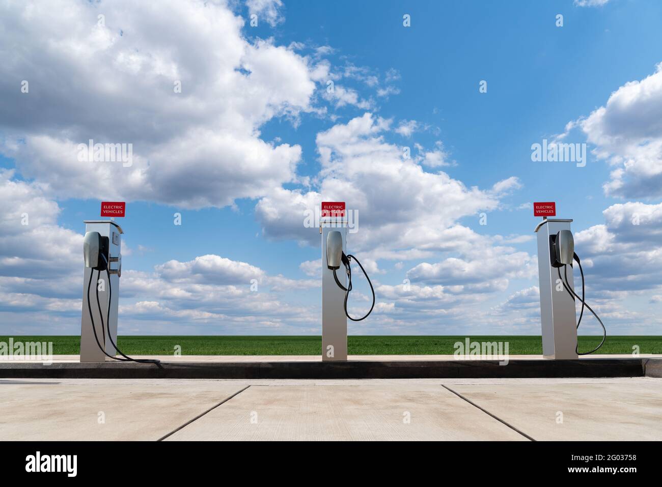 Charging stations for electric vehicles with green field and blue sky ...