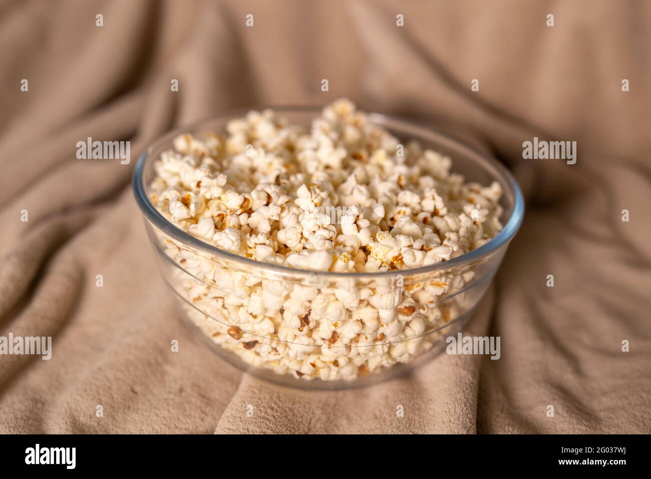 Bowl of popcorn for watching a film on a beige couch. Snacks and ...